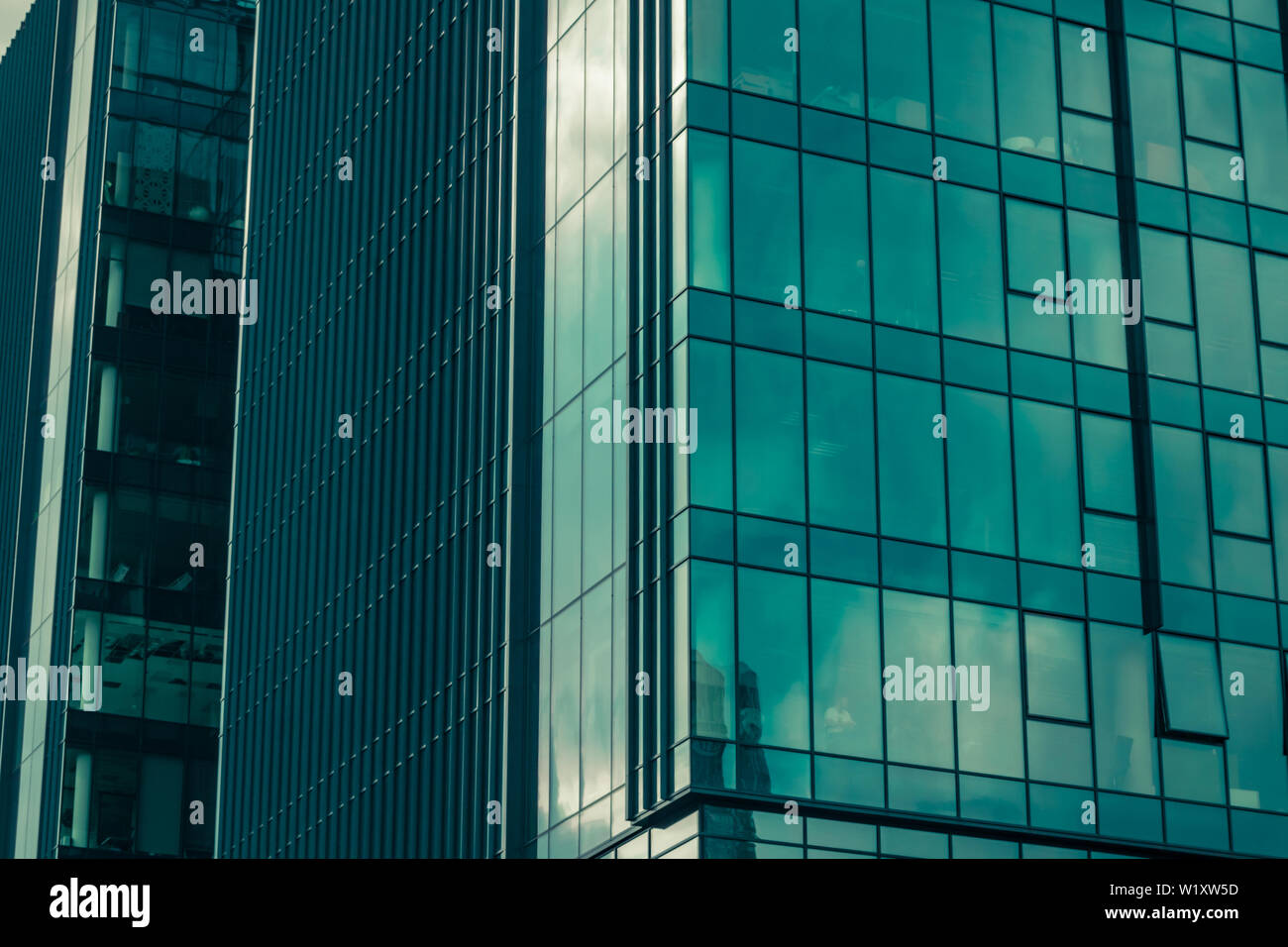 Sky with clouds reflected in windows of modern office building ...