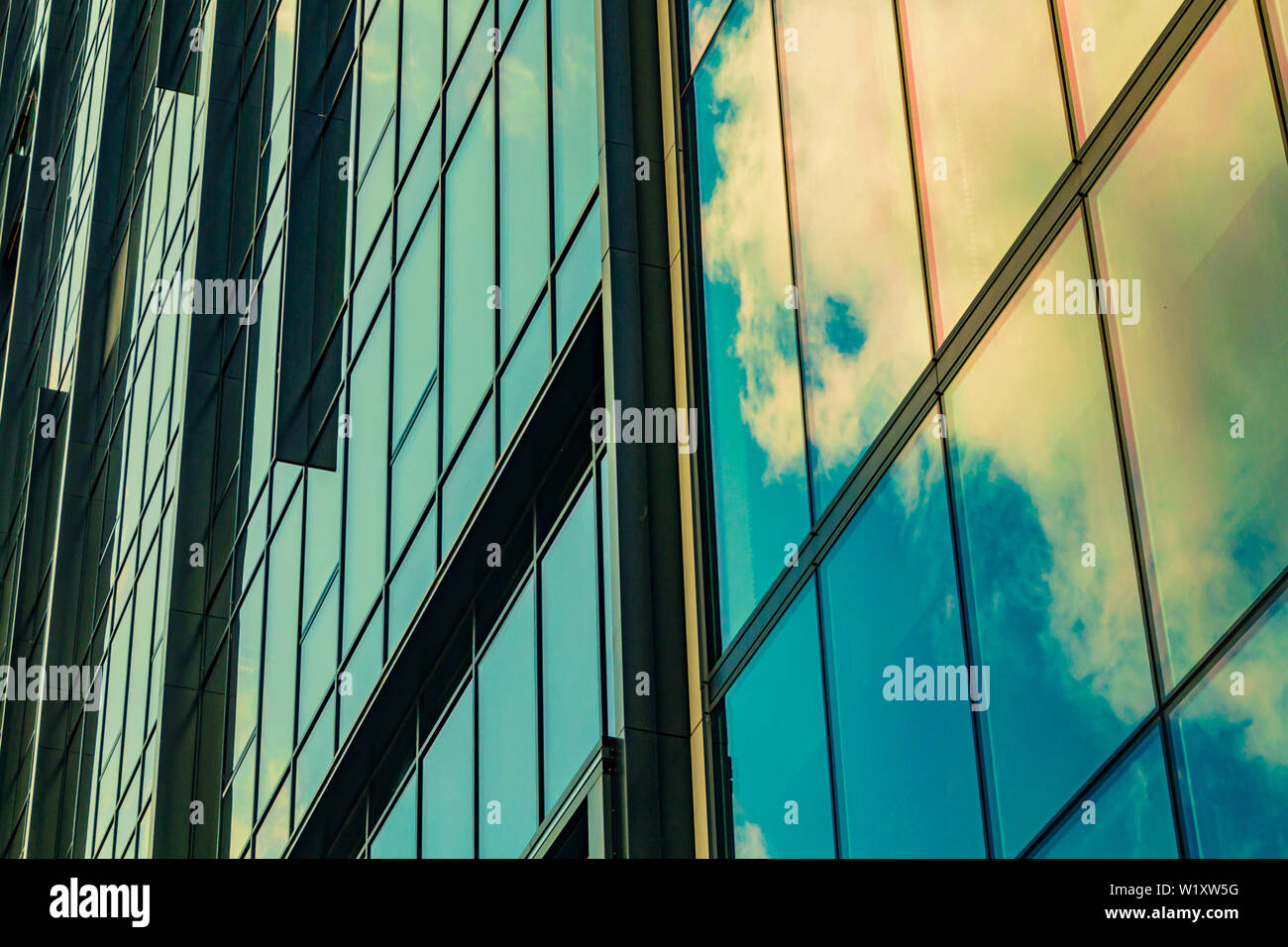 Sky with clouds reflected in windows of modern office building ...