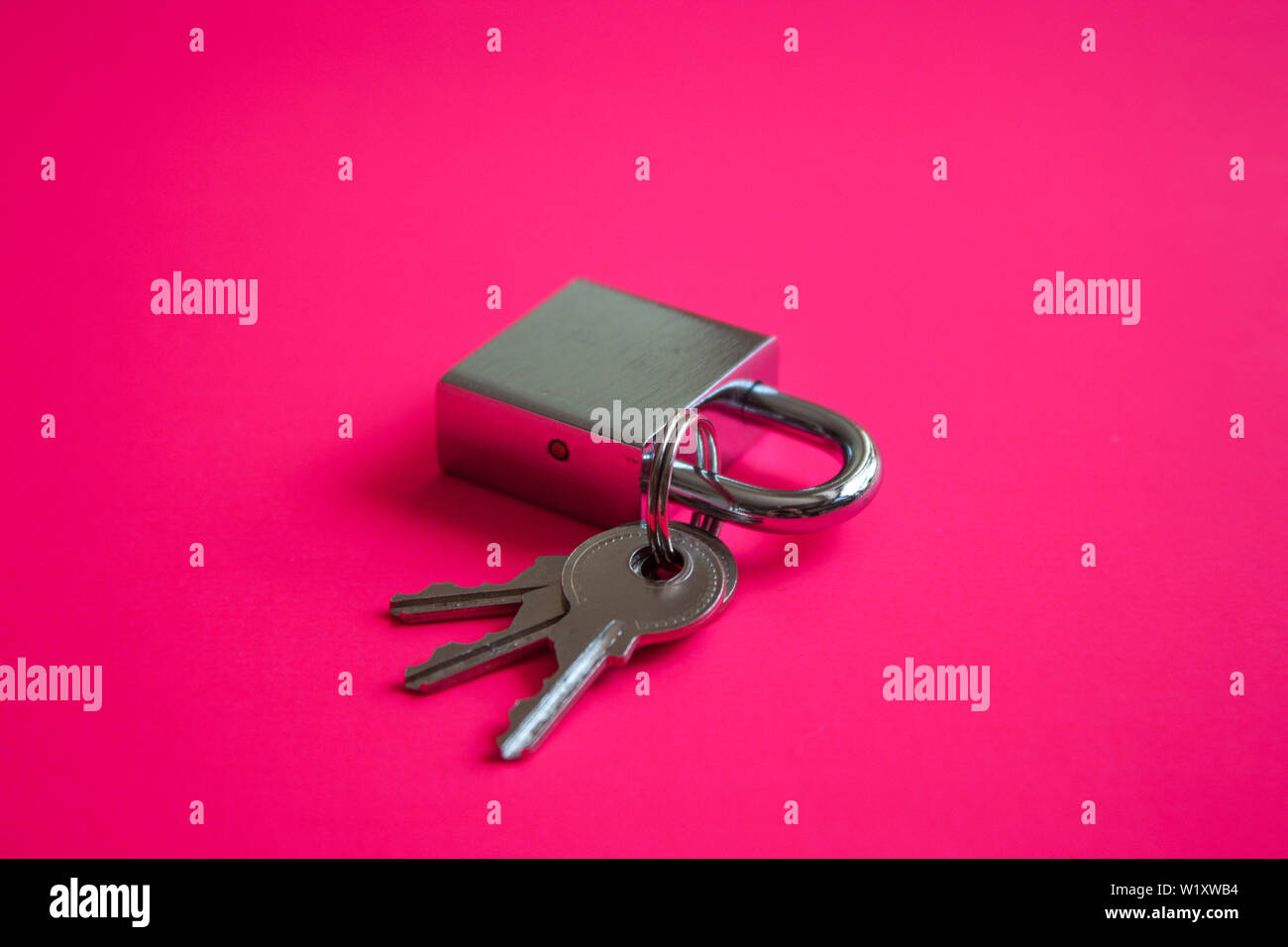 Silver metal check lock and three keys on neon pink background. Modern ...