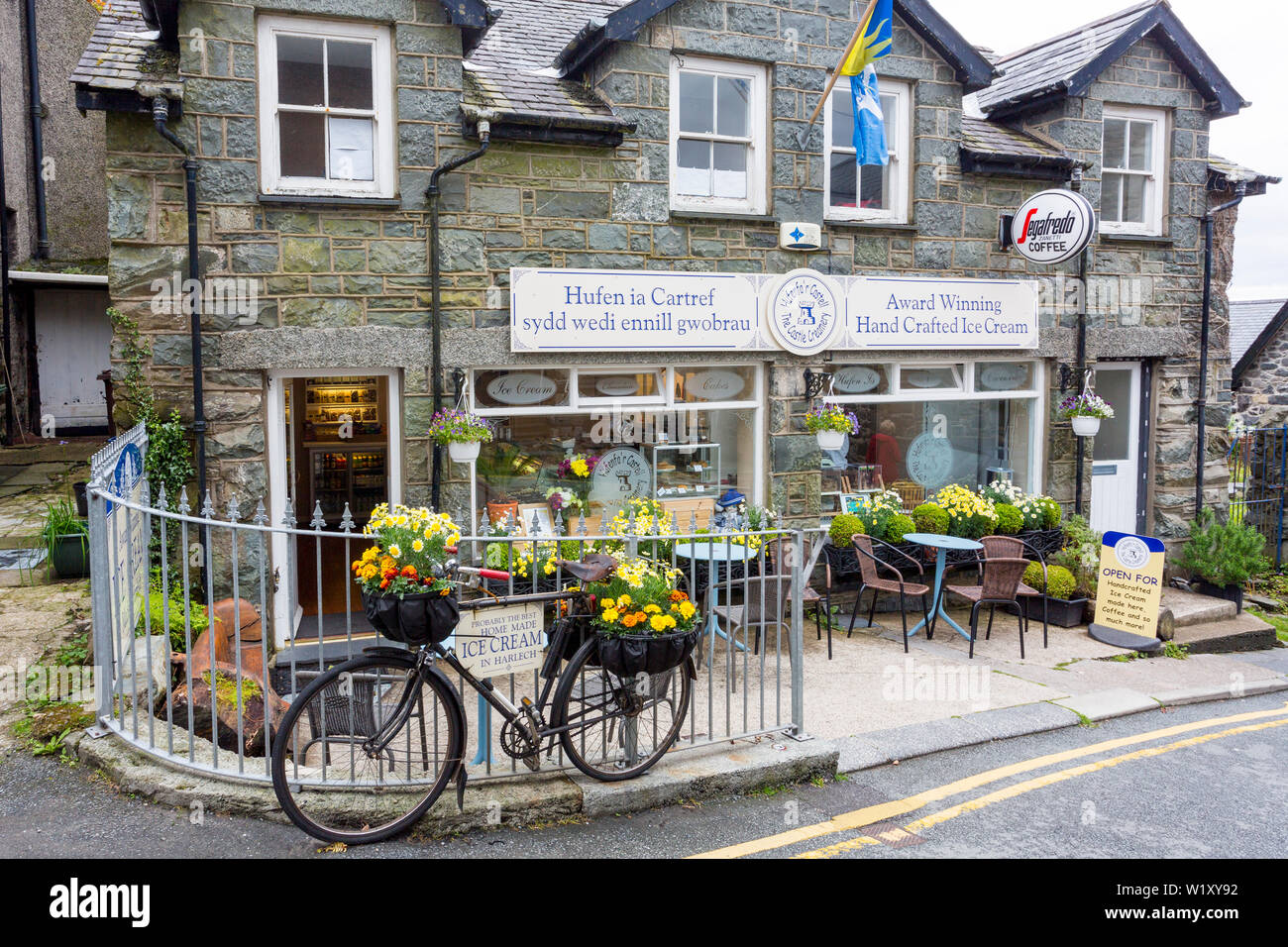 A vintage bicycle with its panniers full of colourful flowers outside ...