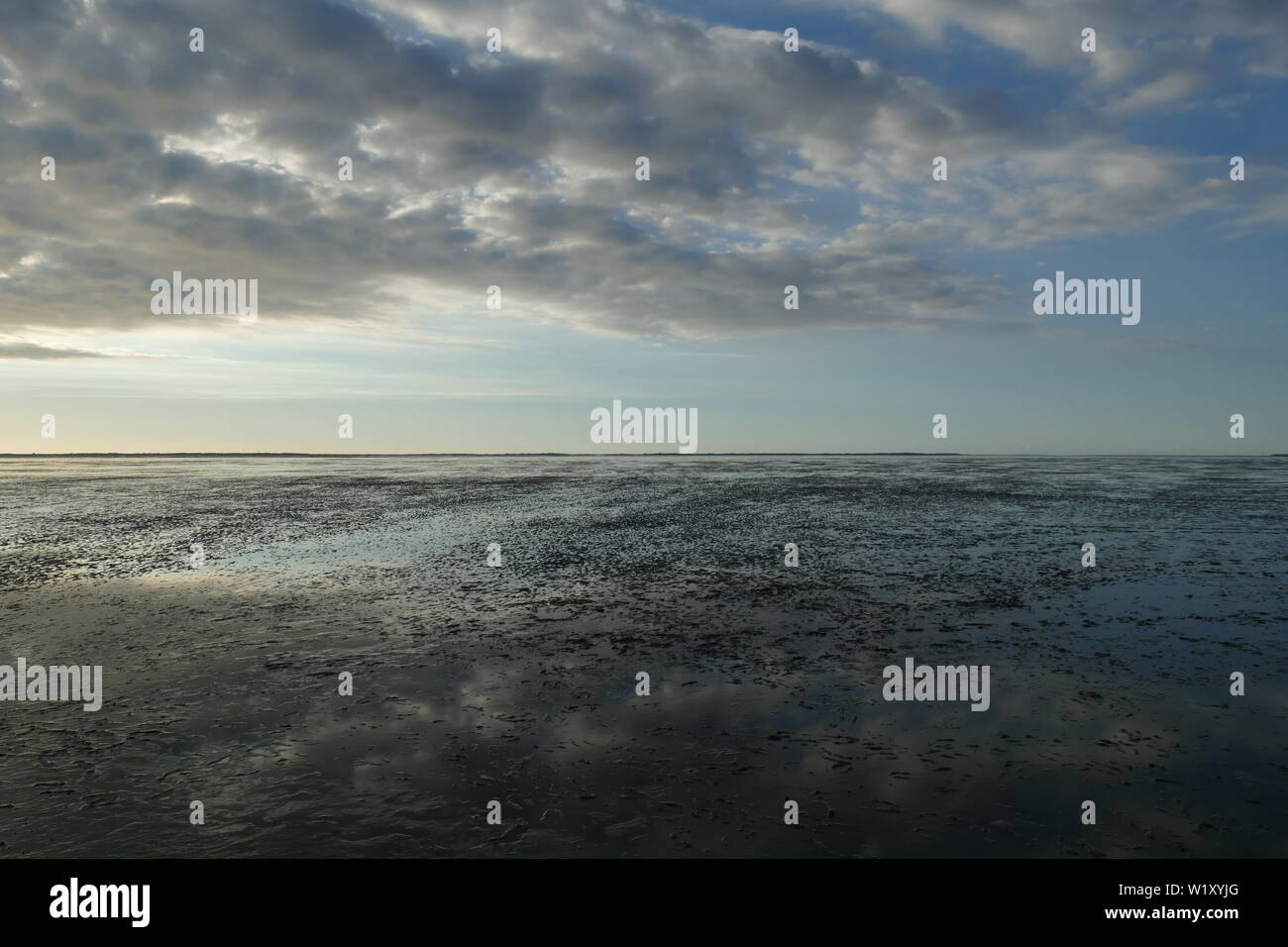 Early sunset on the North Sea directly on the beach. Orange/Blue sky ...