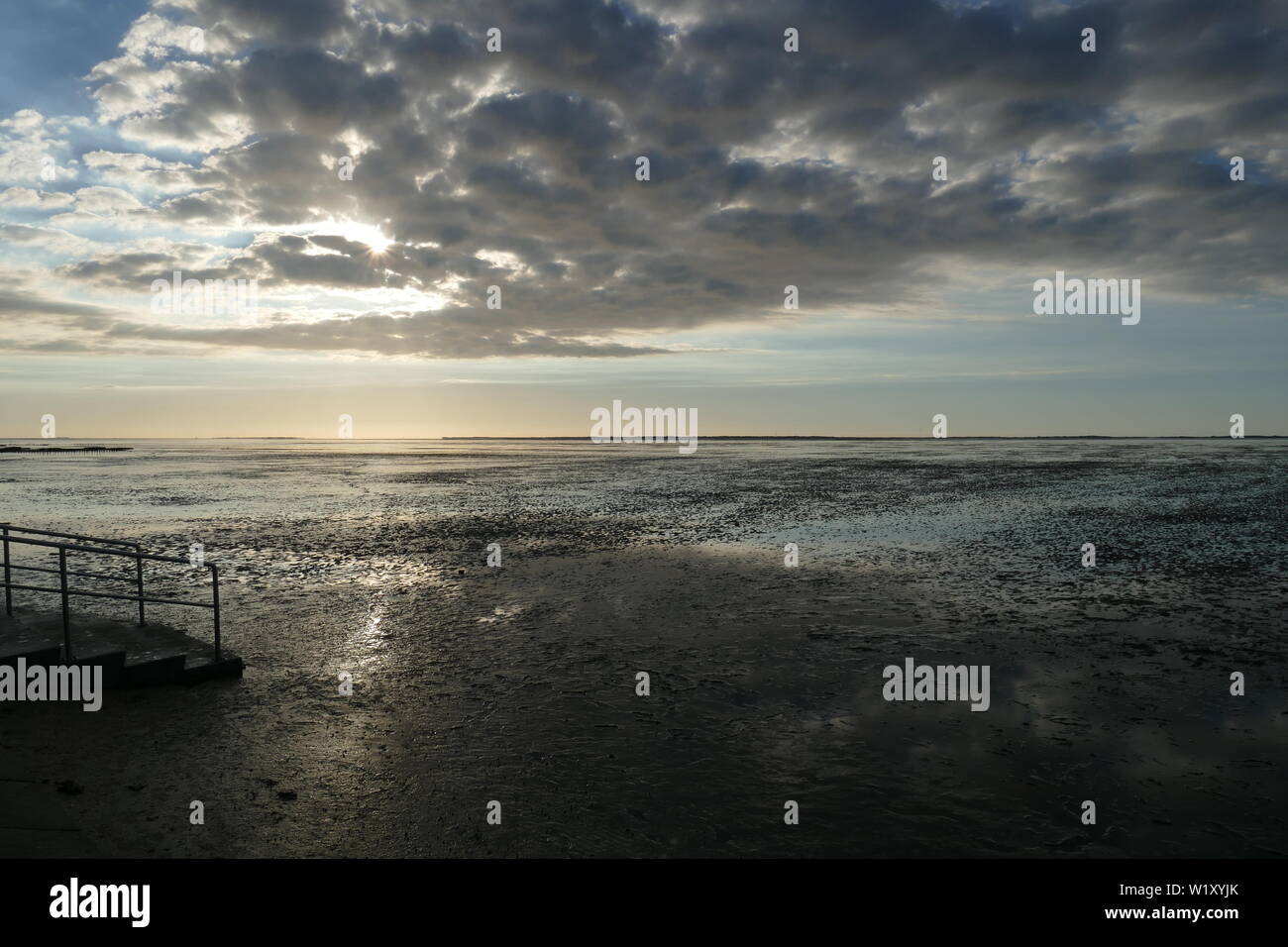 Early sunset on the North Sea directly on the beach. Orange/Blue sky ...
