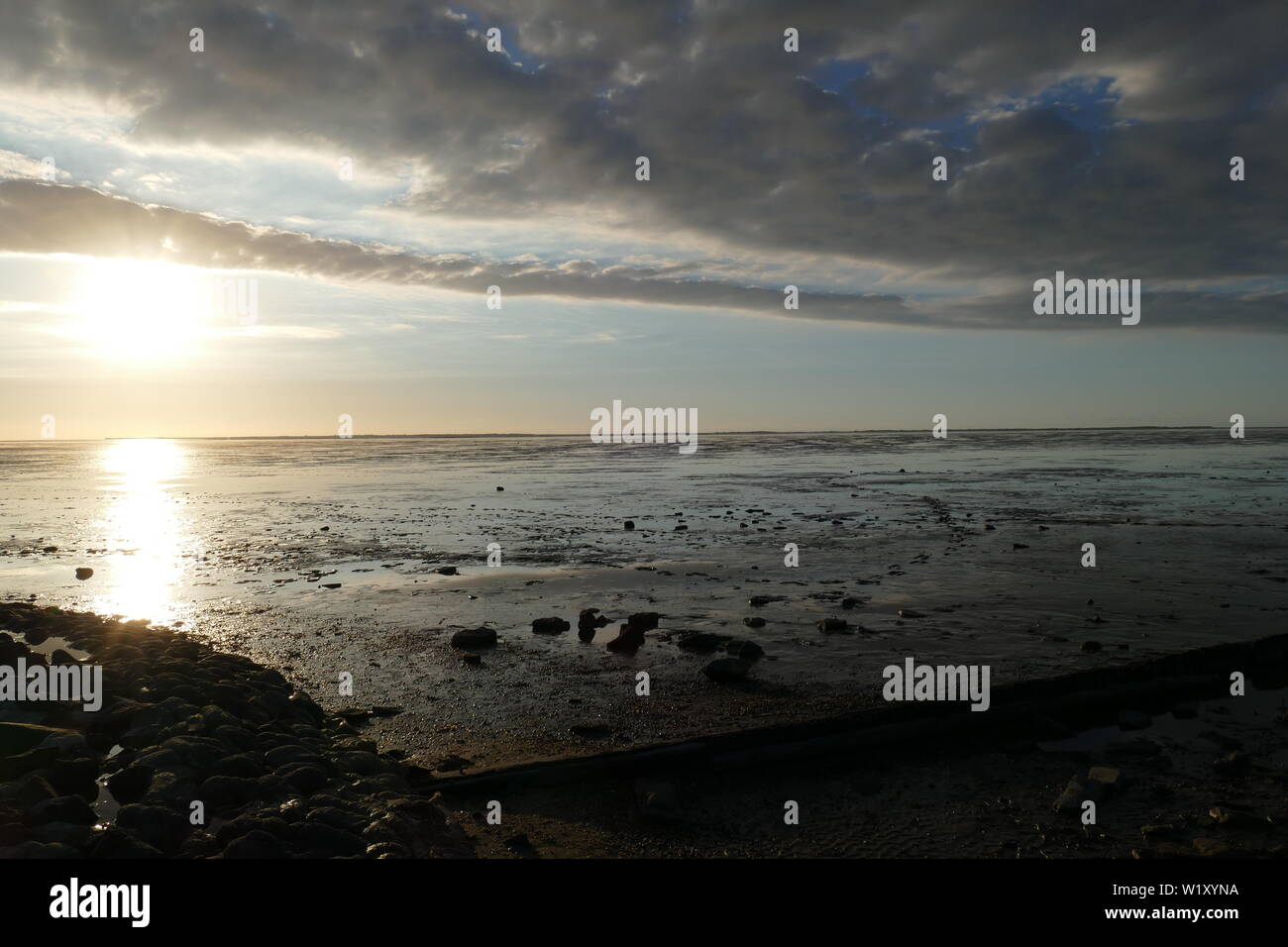 Early sunset on the North Sea directly on the beach. Orange/Blue sky ...