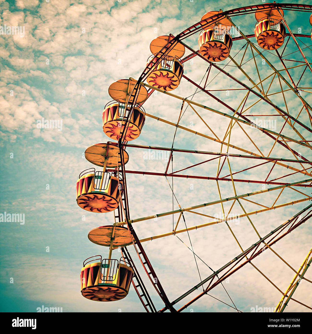 yellow ferris wheel against a blue sky in vintage style Stock Photo - Alamy