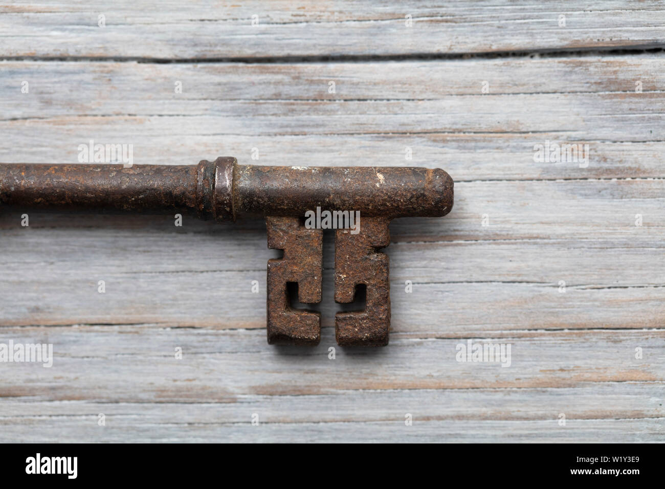 Vintage old fashioned key on a rustic wooden background. Security ...