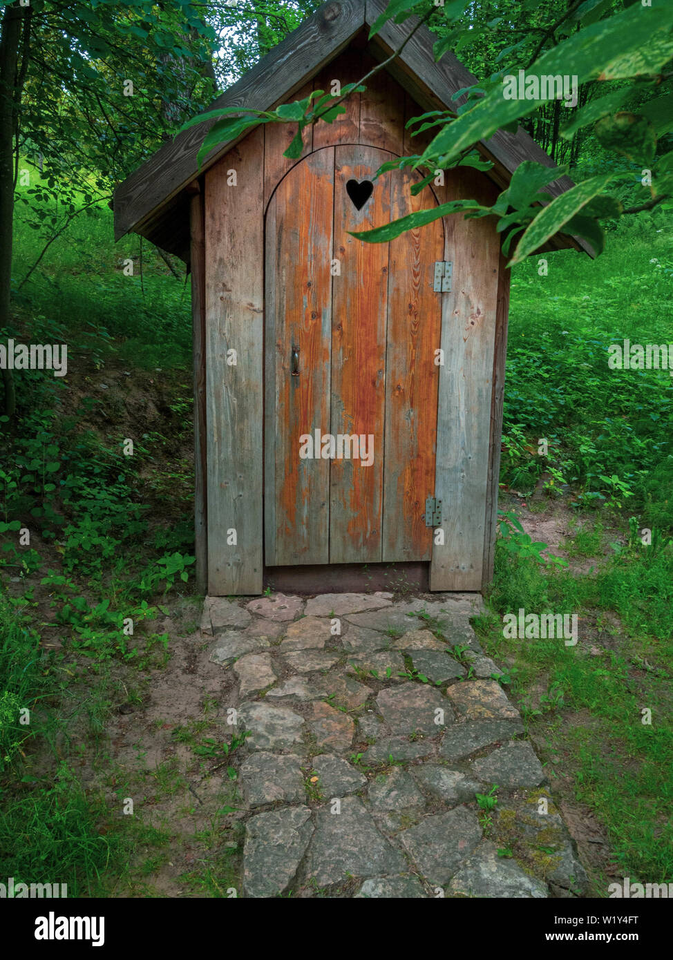 Wooden ecological composting toilet on countryside with a heart shape ...