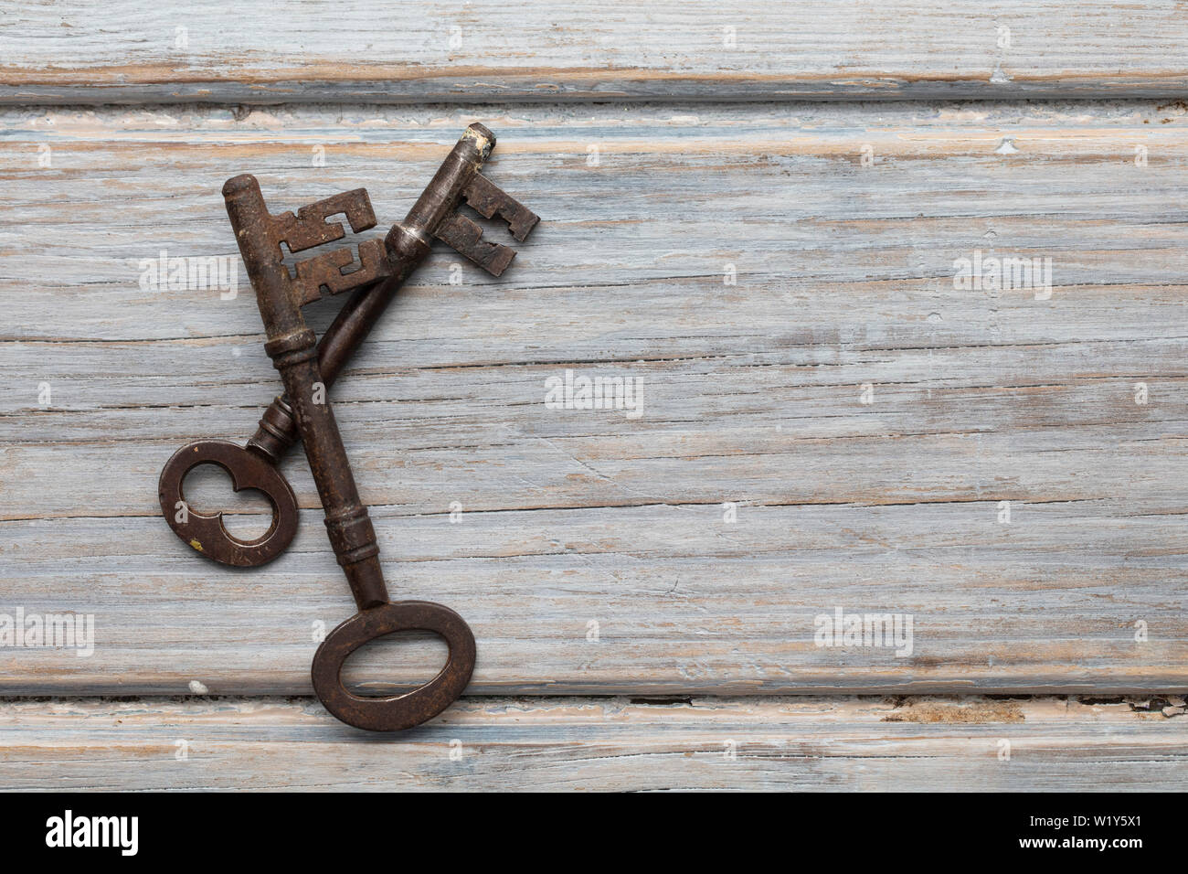 Vintage old fashioned keys on a rustic wooden background. Security ...
