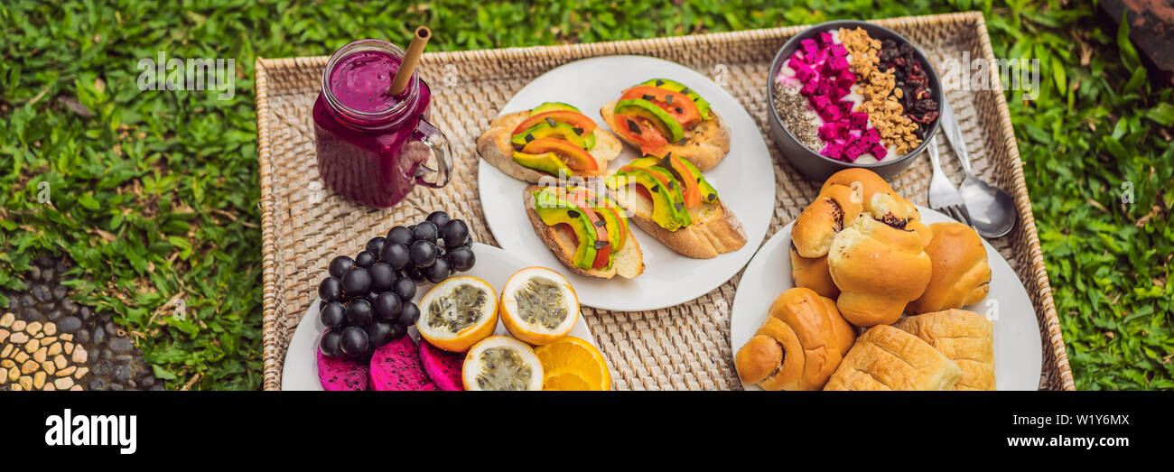 BANNER, LONG FORMAT Breakfast on a tray with fruit, buns, avocado ...
