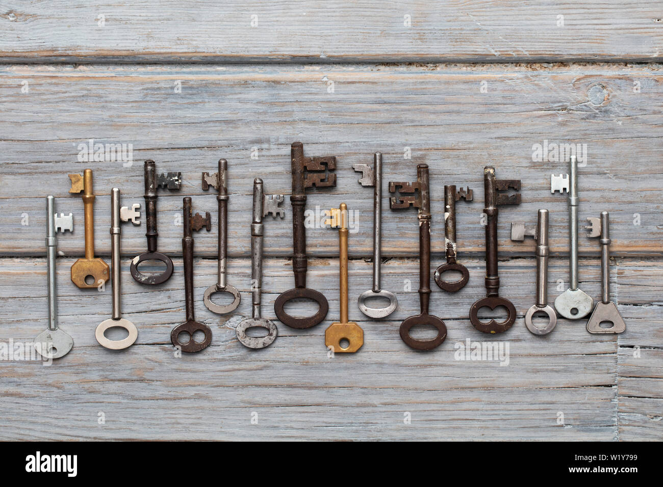Vintage old fashioned keys on a rustic wooden background. Security ...