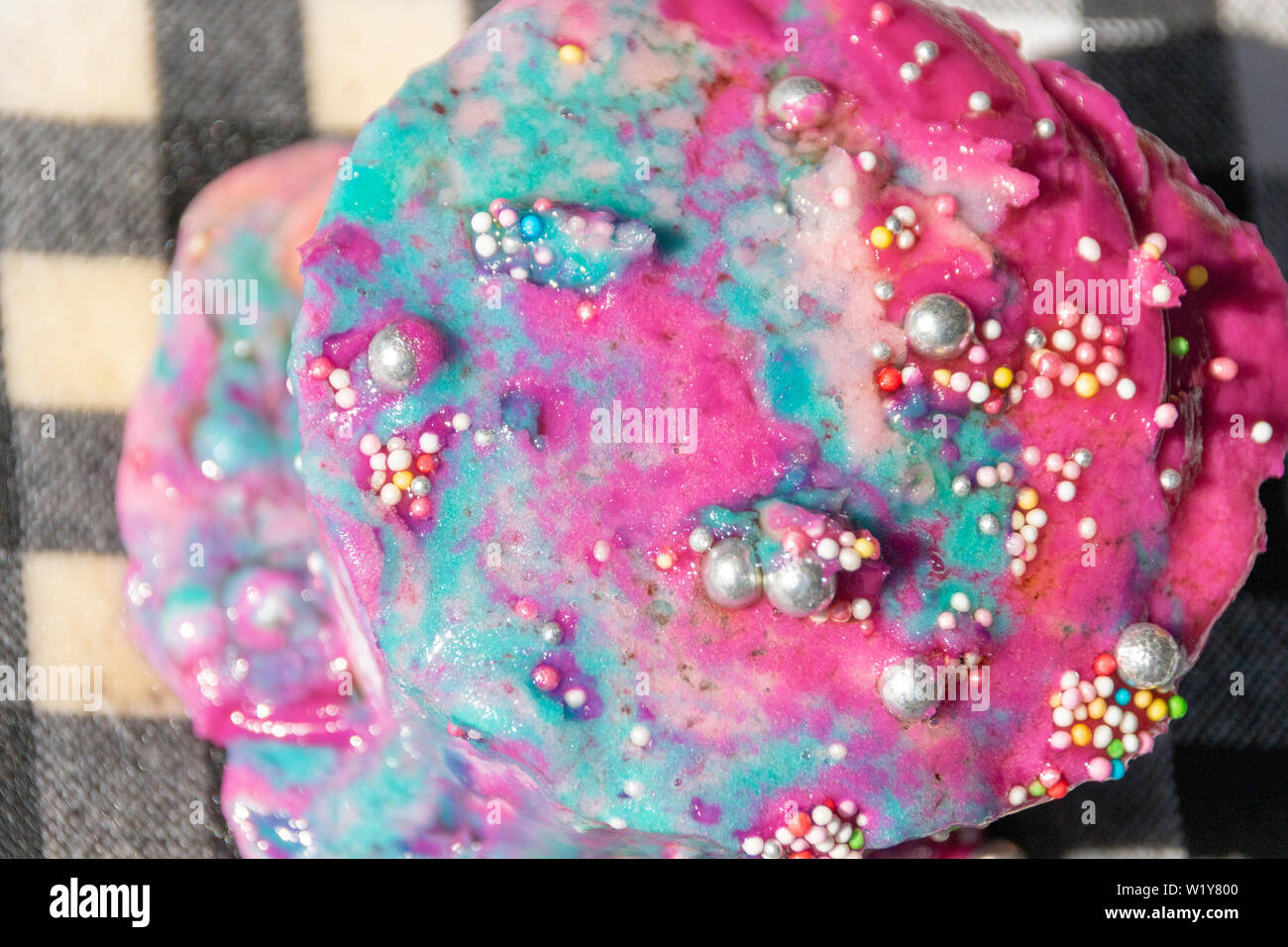 A close up view top of a melted multi colored cupcake with decor ...