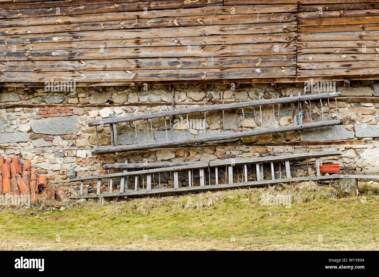 Ancient hayloft with stone wall from below, wooden plank from above and ...