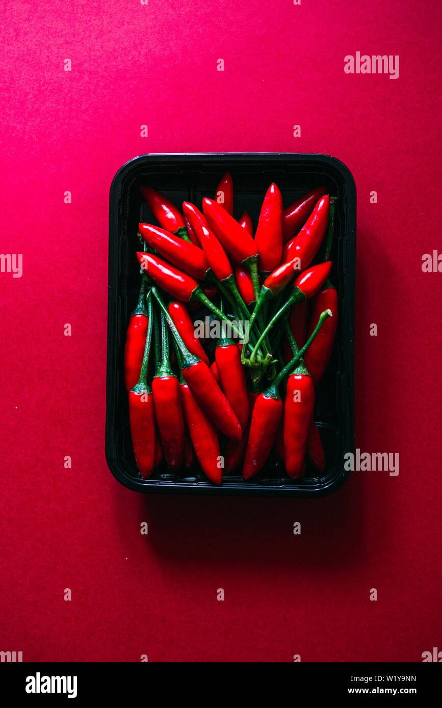 Red Chilli Peppers on black market box rounded by bean sprouts, top ...