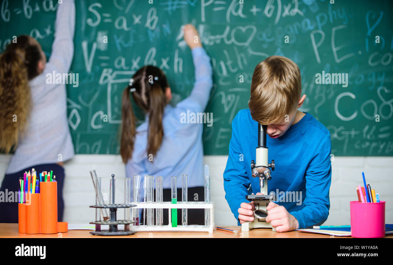 Doing research. Little kids learning chemistry in school lab. Little ...