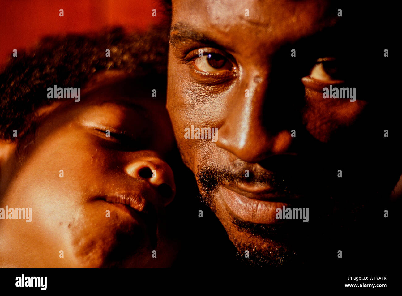 London, 1990. Portrait of boxer Nigel Benn with his son Dominic ...