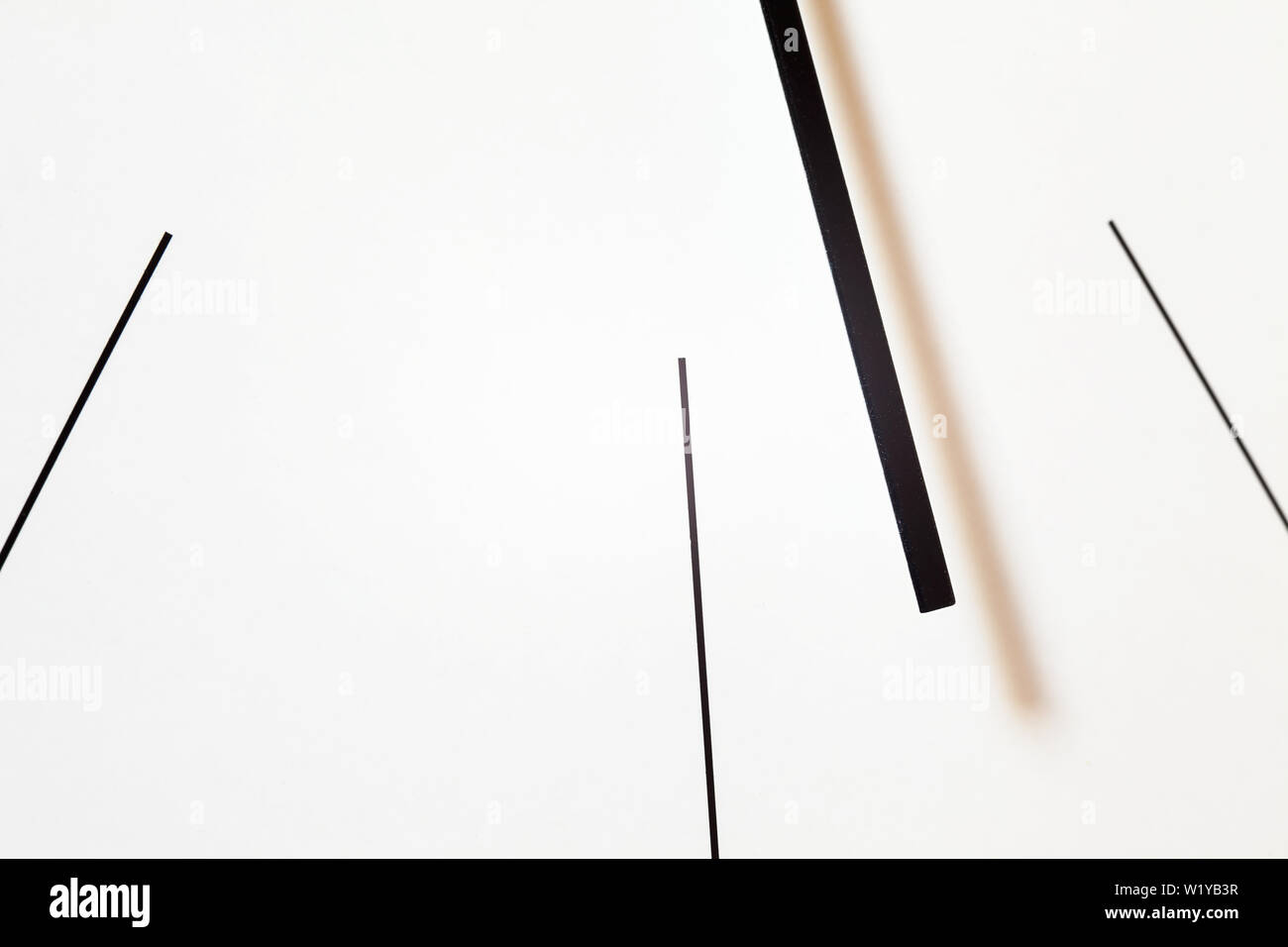 Closeup view of a simple wall watch, details of minute and hour hands ...