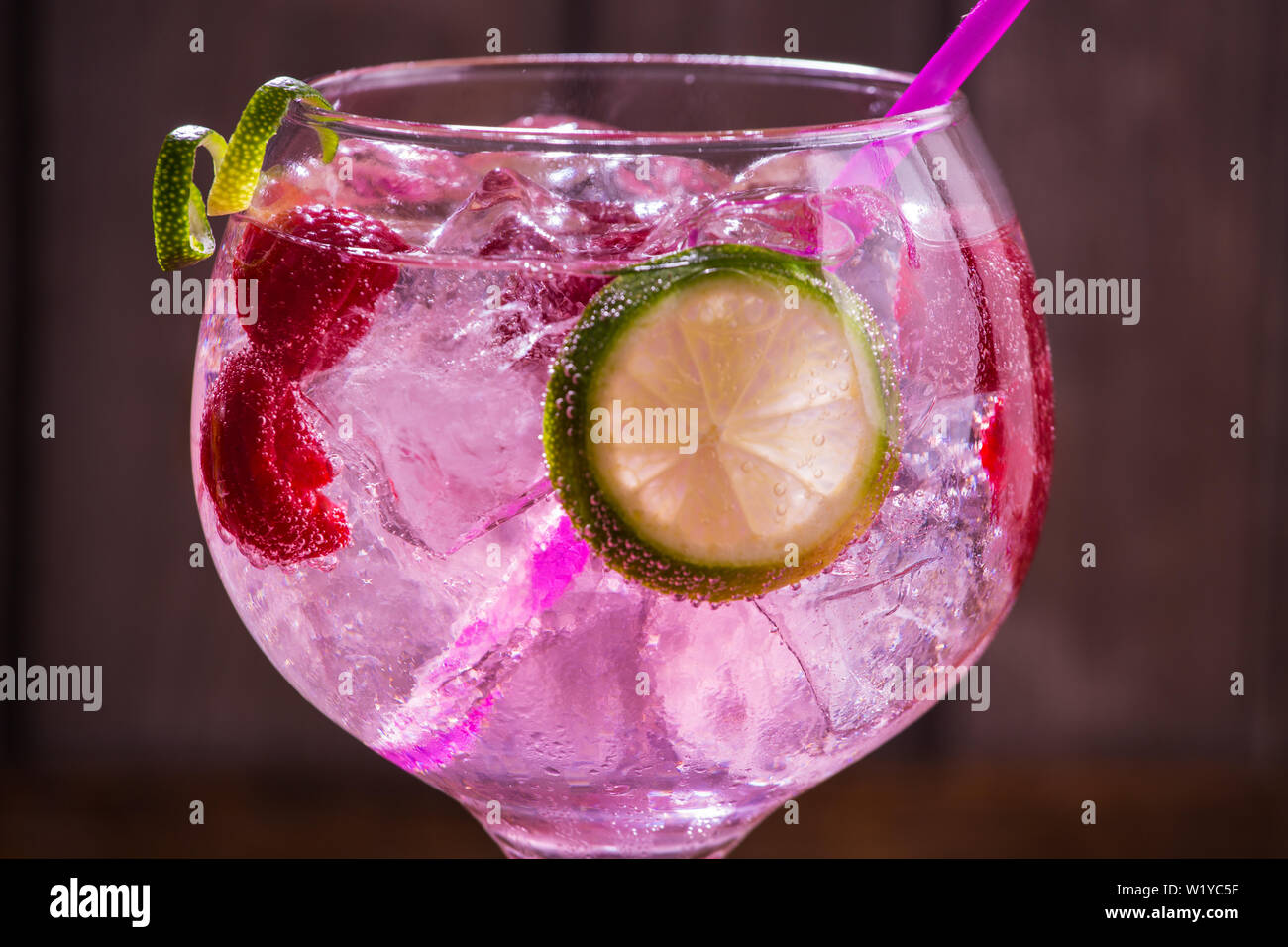 Pink tonic gin with raspberries, wooden background Stock Photo - Alamy