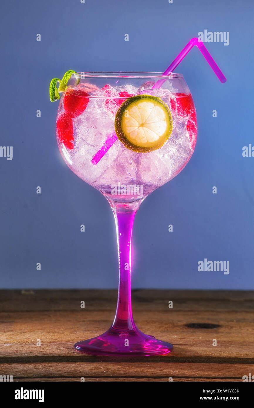 Gintonic rose with raspberries, on blue background Stock Photo - Alamy