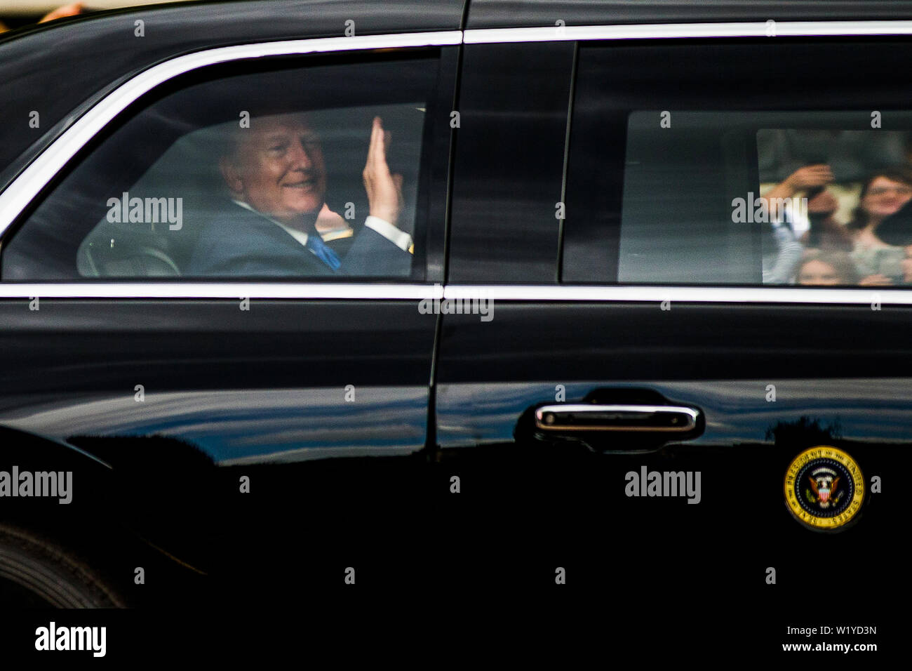US President Donald Trump waves from his motorcade as it makes it’s way ...