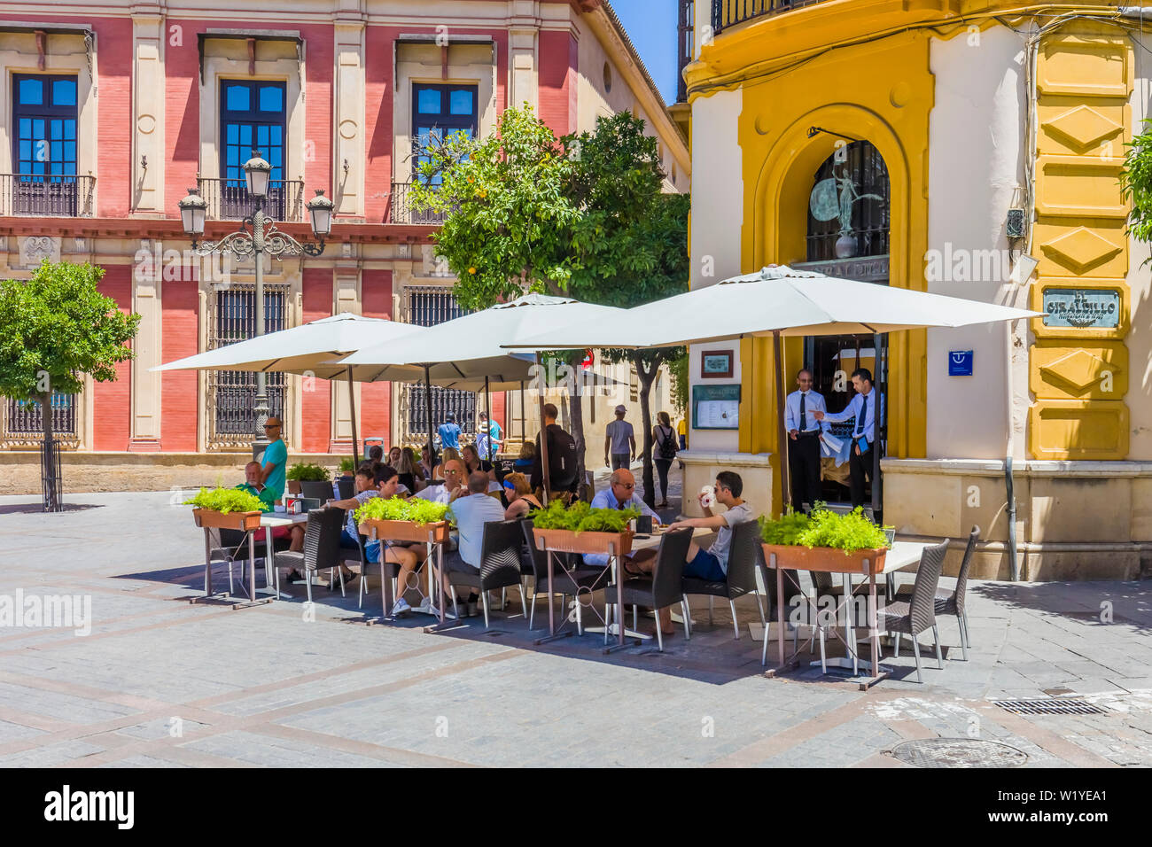 People at outdoor street cafe in historic downtown centre of Seville ...