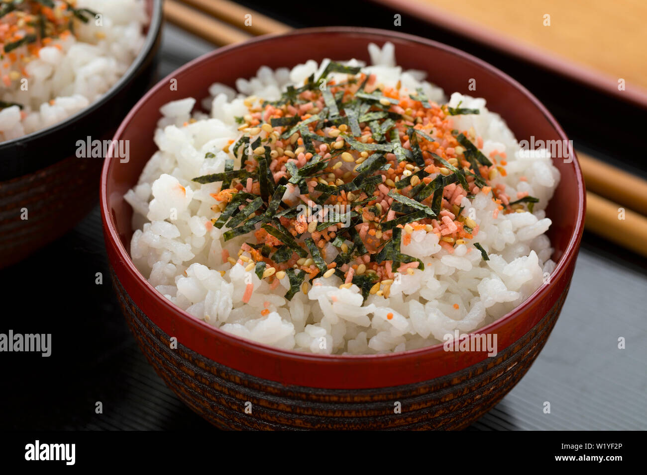 Traditional lacquered Japanese bowl with white rice and furikake close ...