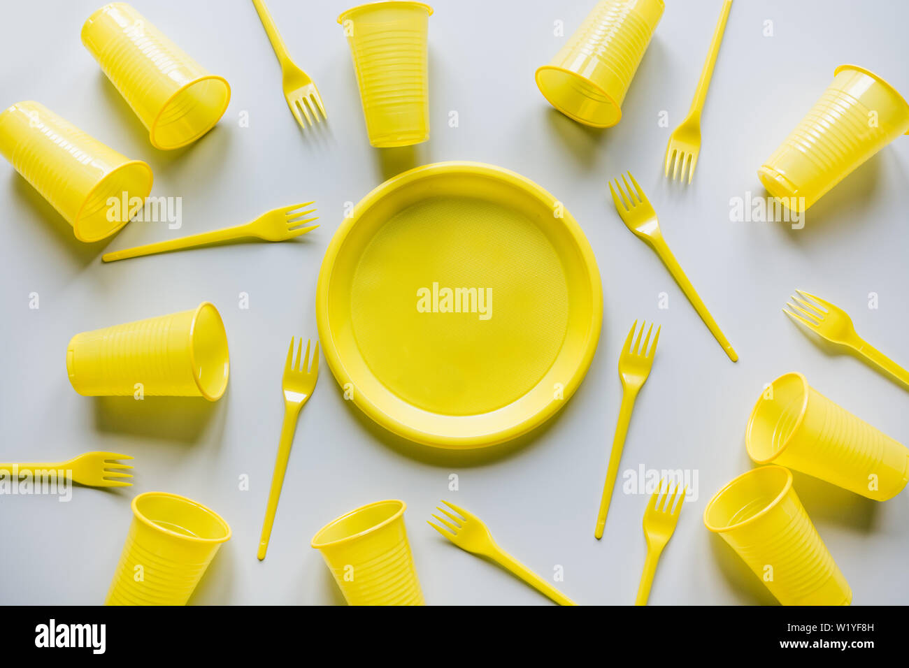Single use yellow picnic utensils on grey. Environment, eco friendly ...