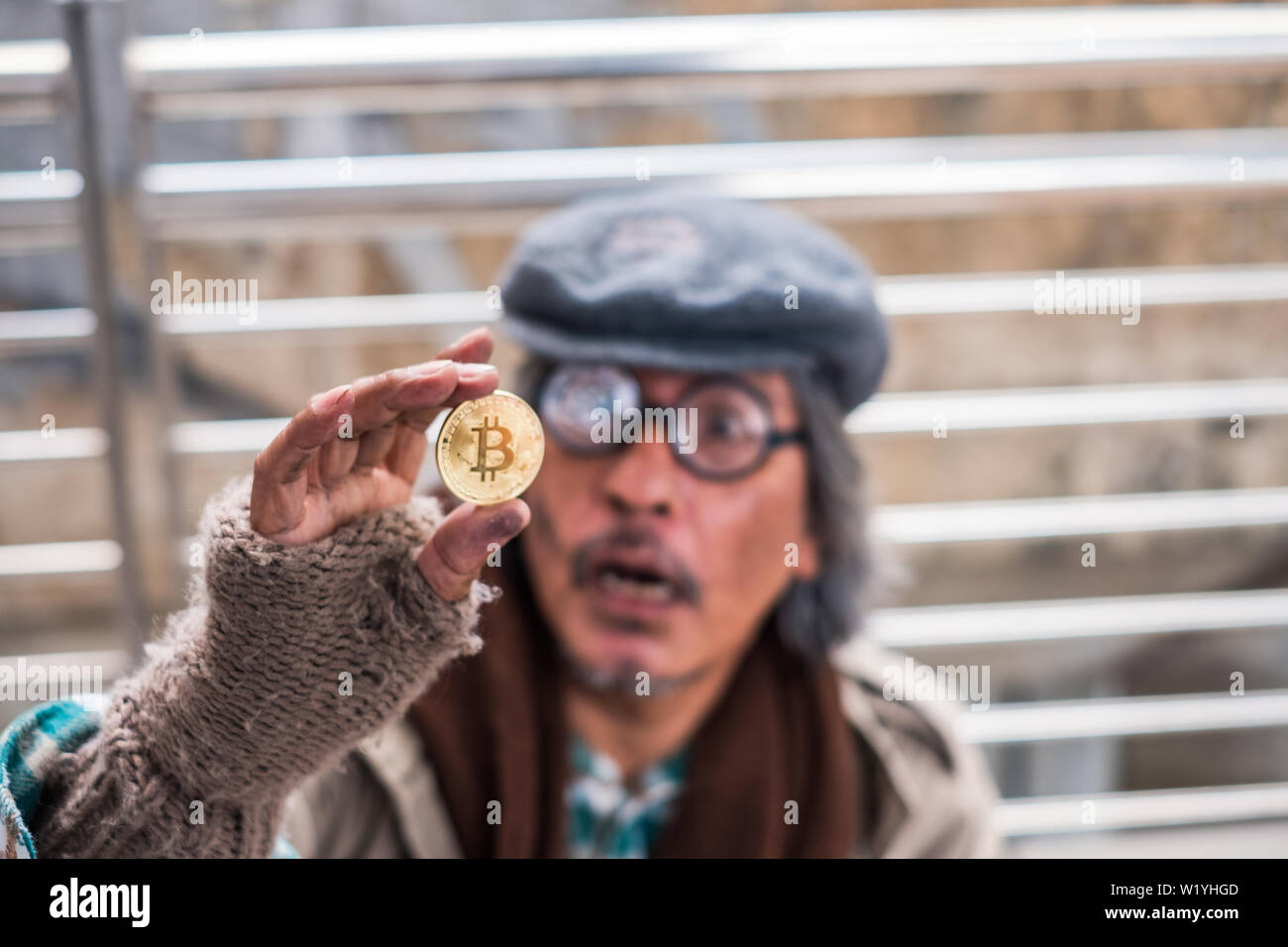Old dirty homeless man holding golden bitcoin with looking excited ...