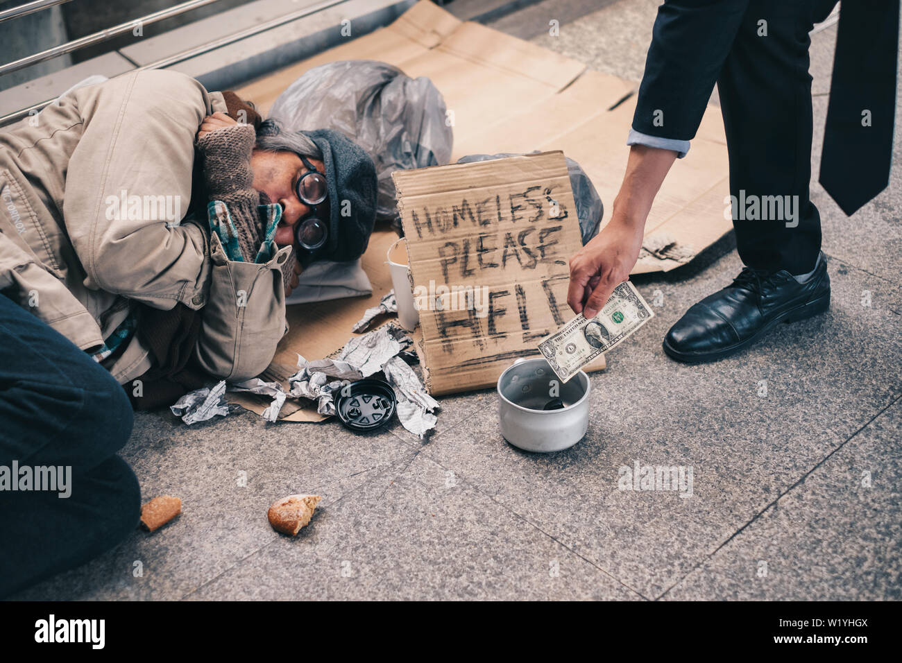 Businessman giving donation dollar cash with sleeping old homeless ...