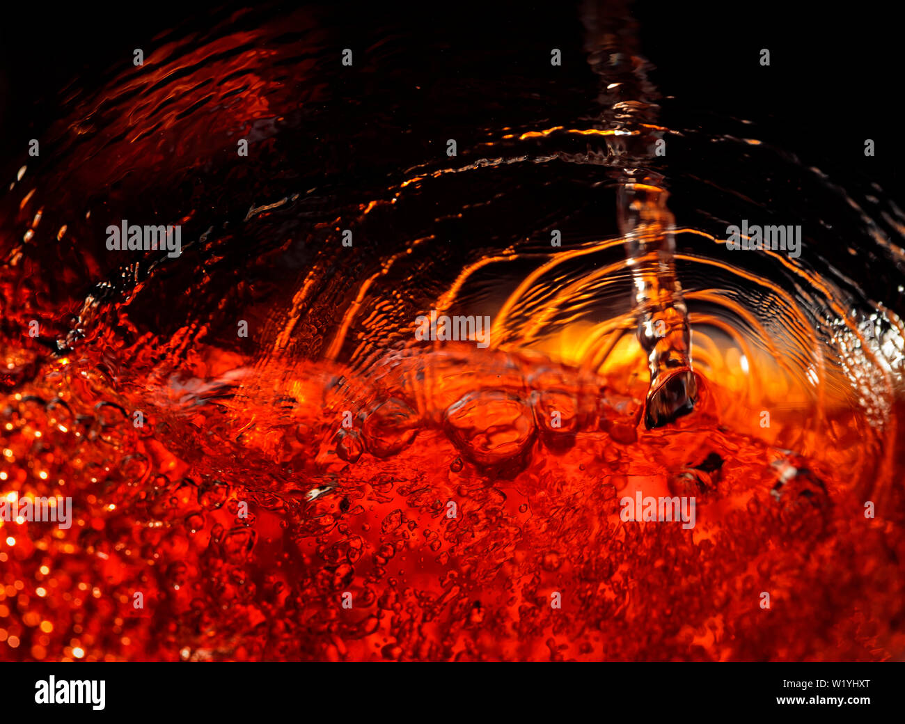 Alcoholic drink on a dark background, abstract splashing. Macro shot ...