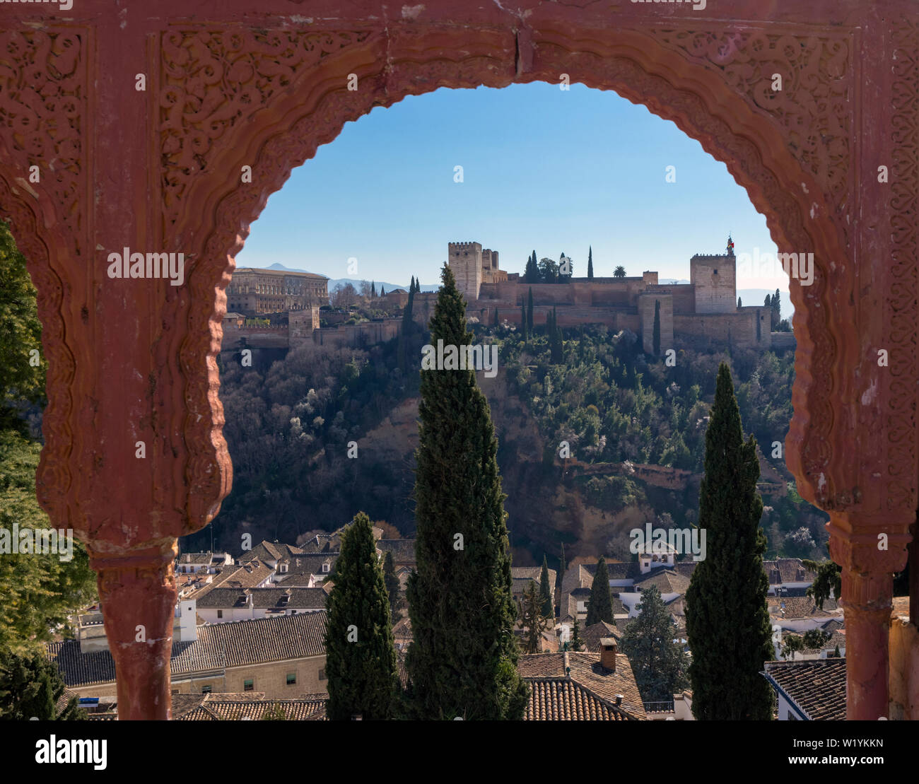 View through a Moorish arch across the Albayzin to the Alhambra ...