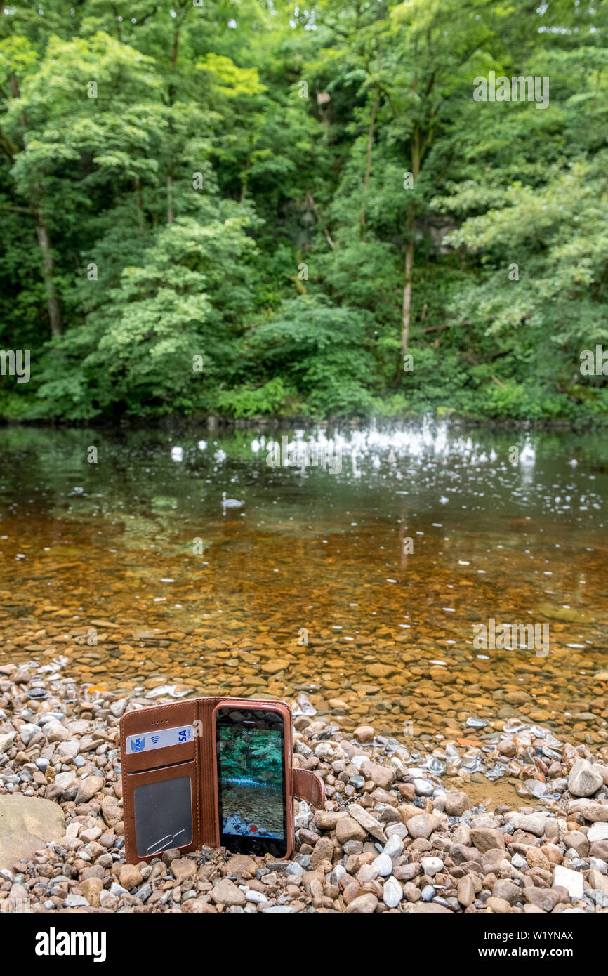 Filming stones making a splash using an iphone Stock Photo - Alamy