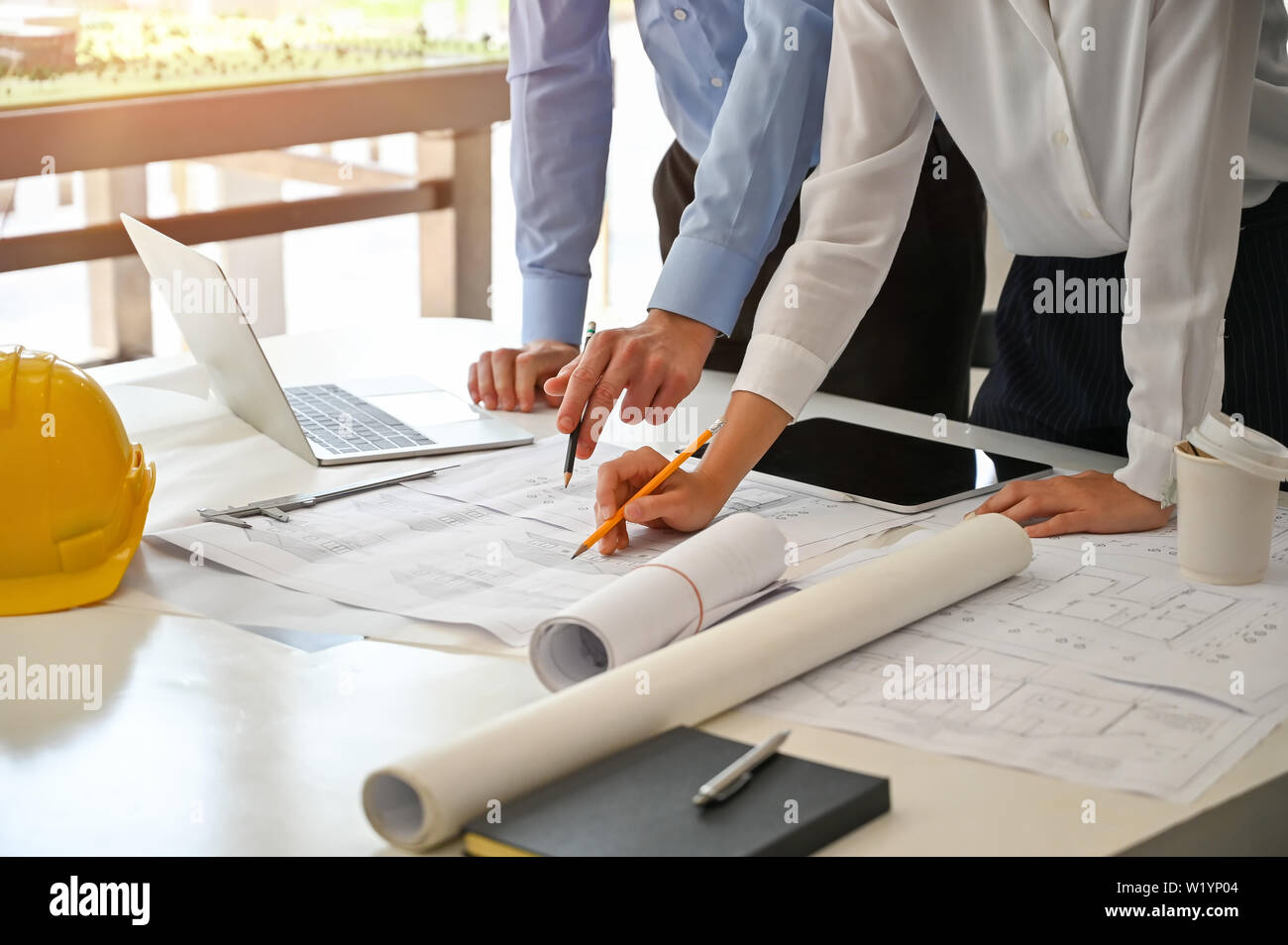 Architect meeting with blueprint on creative workspace Stock Photo - Alamy