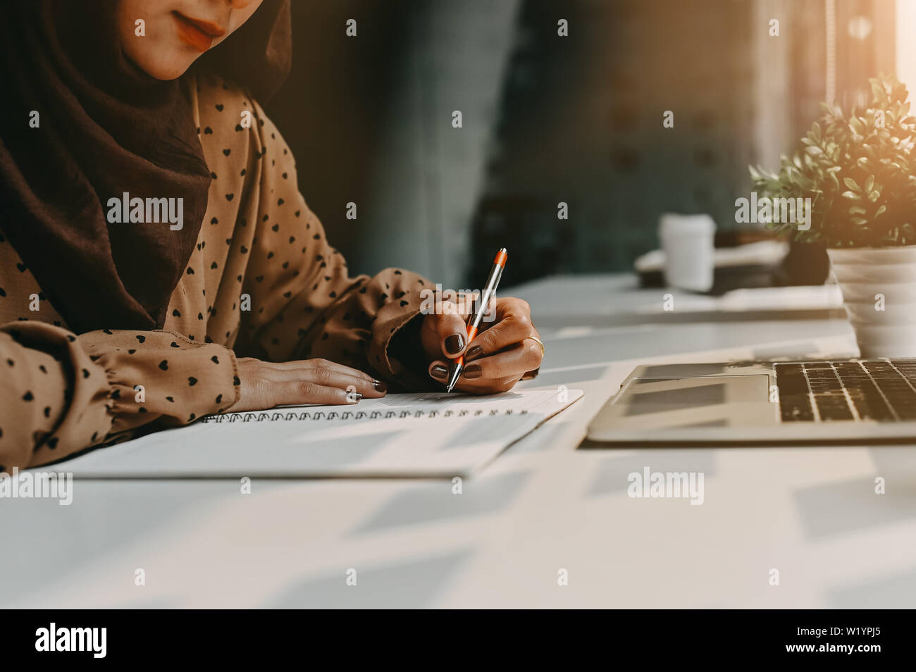 Cropped shot islam female working on table Stock Photo - Alamy
