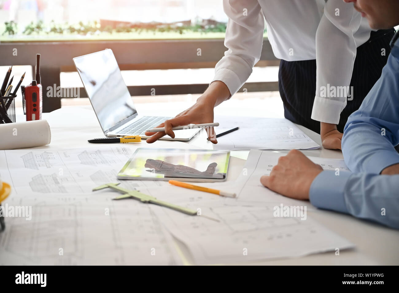 Team architect meeting and consult with blueprint and computer in ...