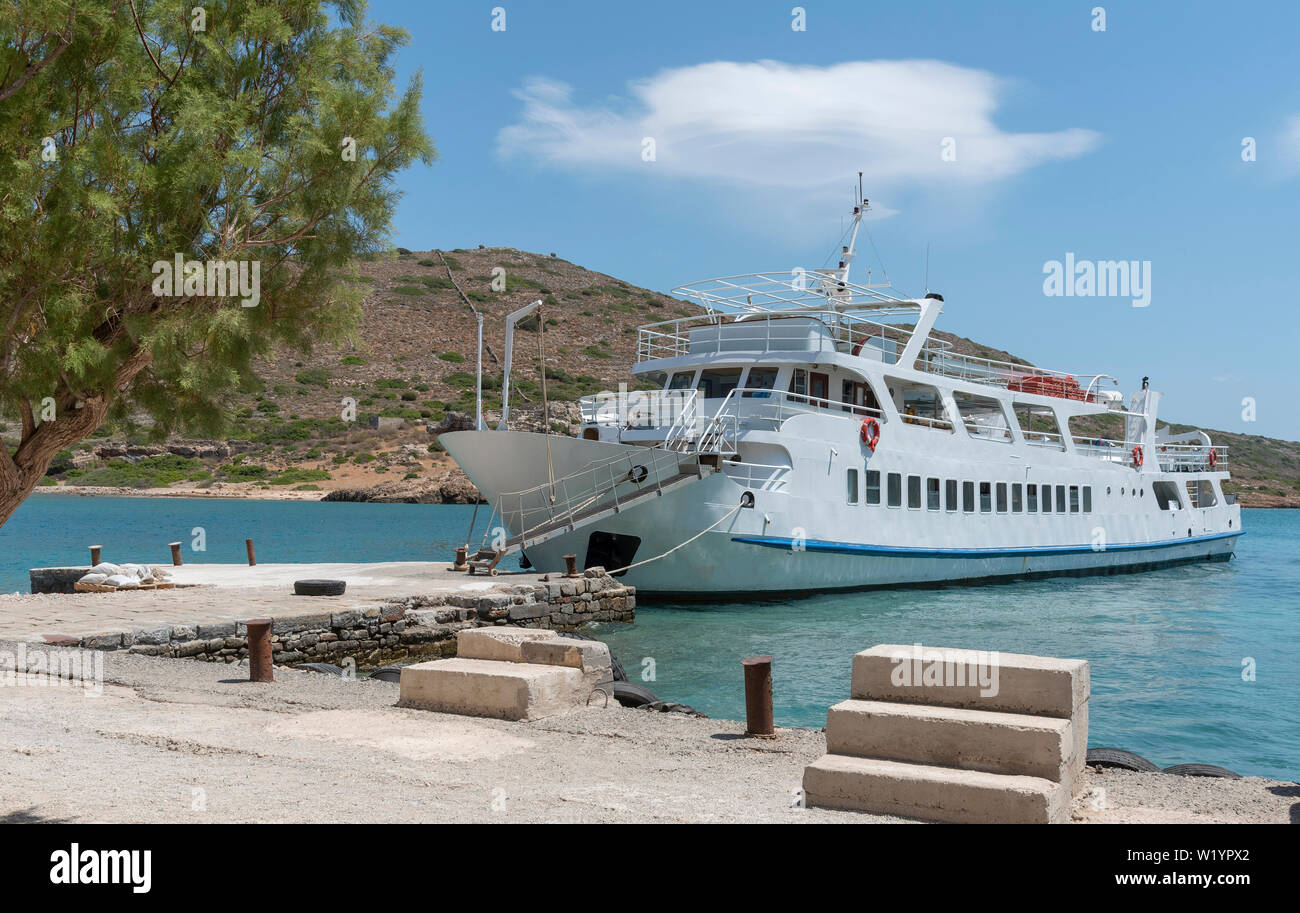 Crete, Greece. June 2019. A ferry boat tied to moorings in a small ...