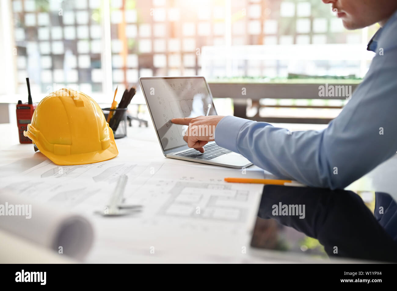 Architect man working on blueprint with engineer planing on office desk ...