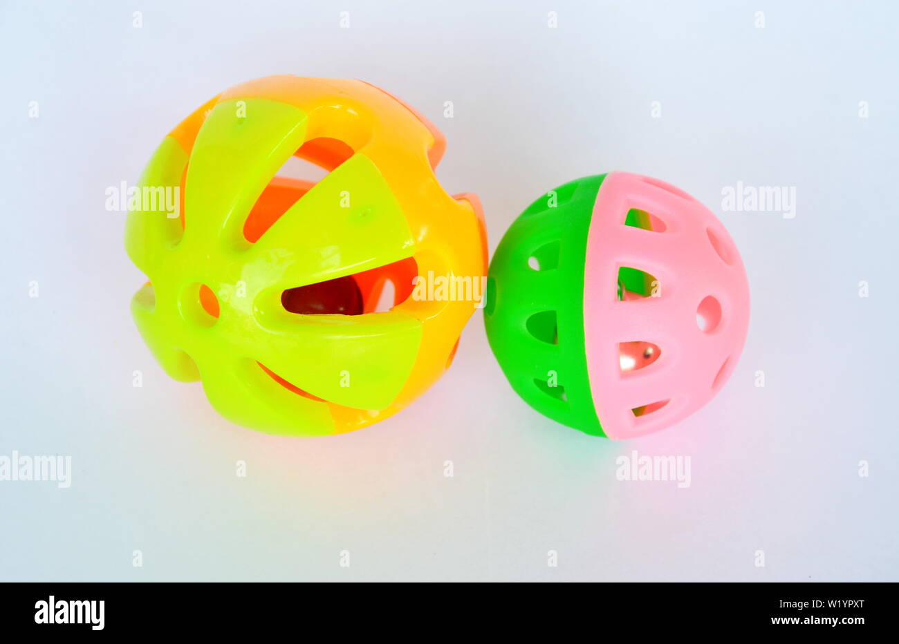 dog and cat colorful plastic toy ball and bell on white background ...