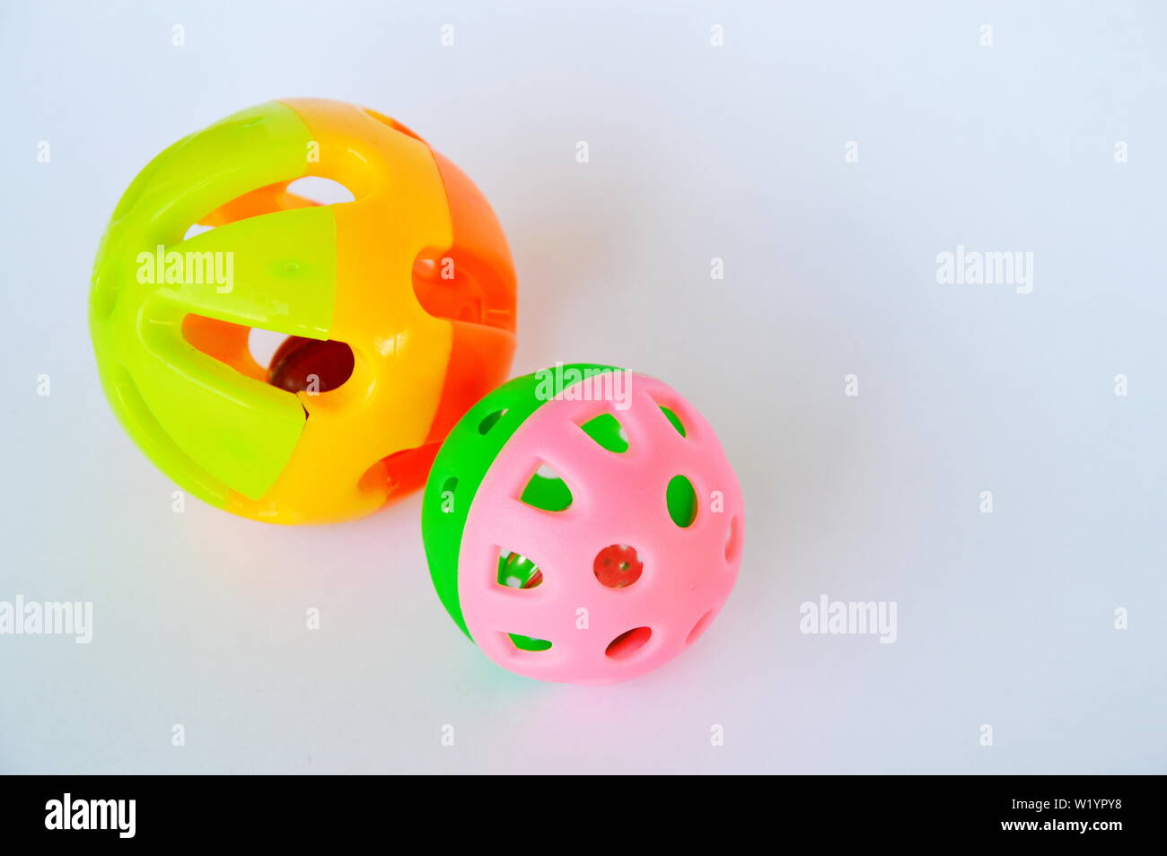 dog and cat colorful plastic toy ball and bell on white background ...