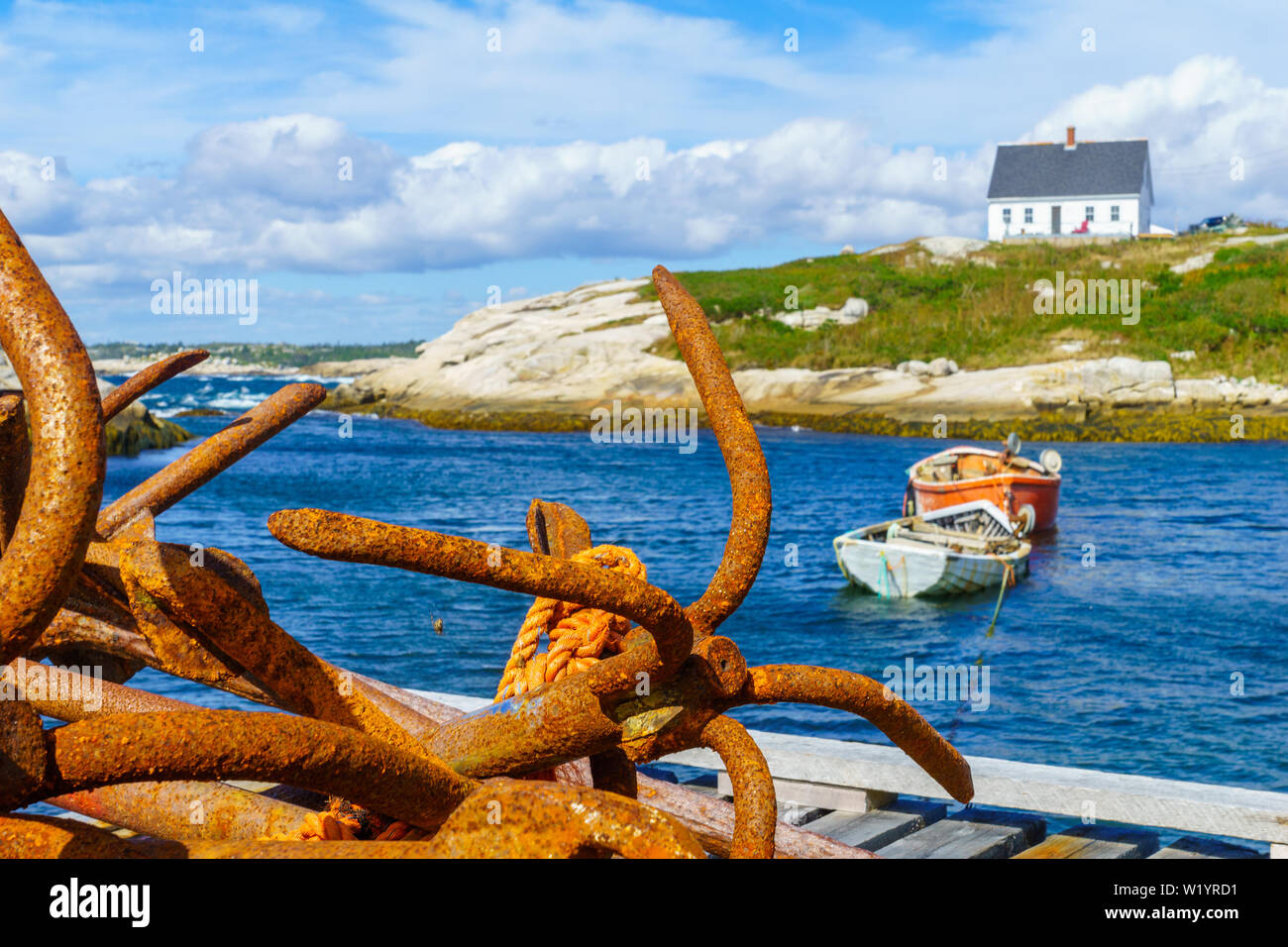 View of rusty anchors, boats and houses, in the fishing village Peggys ...