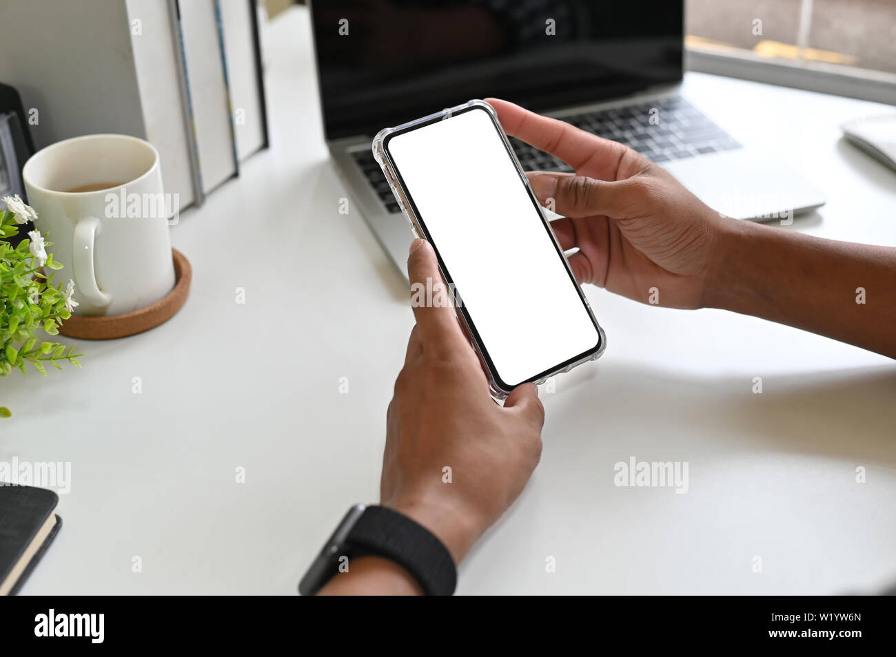 Cropped shot hands using mockup smartphone on office desk with clipping ...