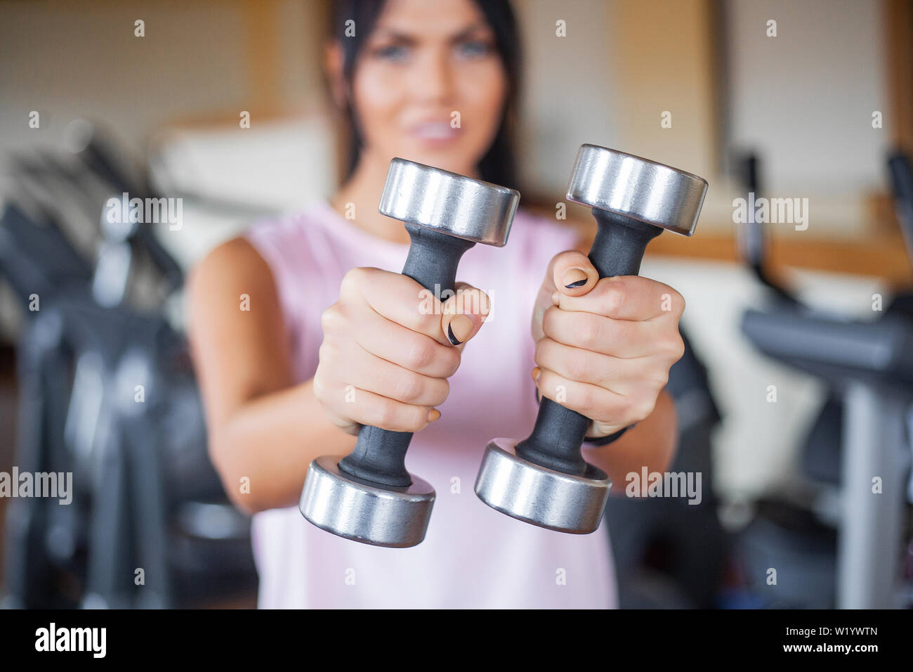 Concept of sport and healthy lifestyle. Young woman with dumbbell make ...