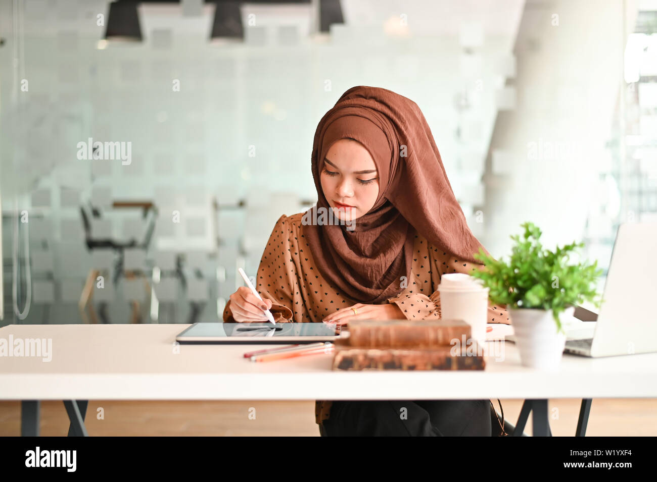 Islam woman working with digital tablet and pen on office workplace ...
