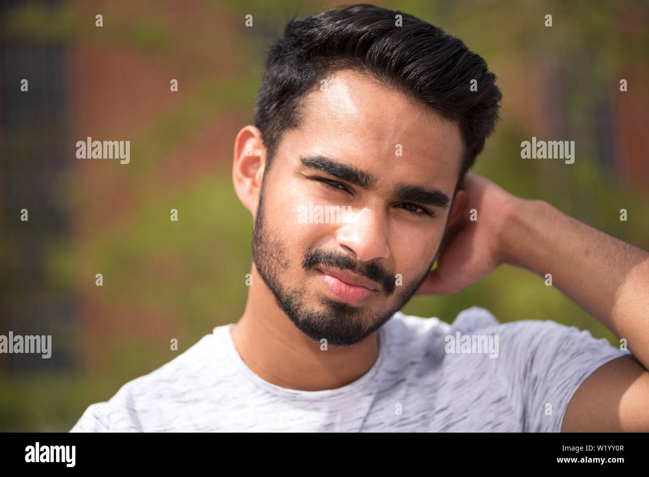 young male model posing in front of old industrial building in Lisbon ...