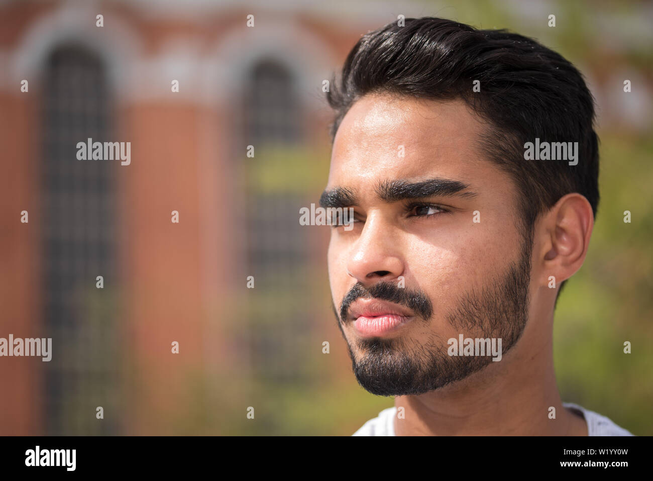 young male model posing in front of old industrial building in Lisbon ...