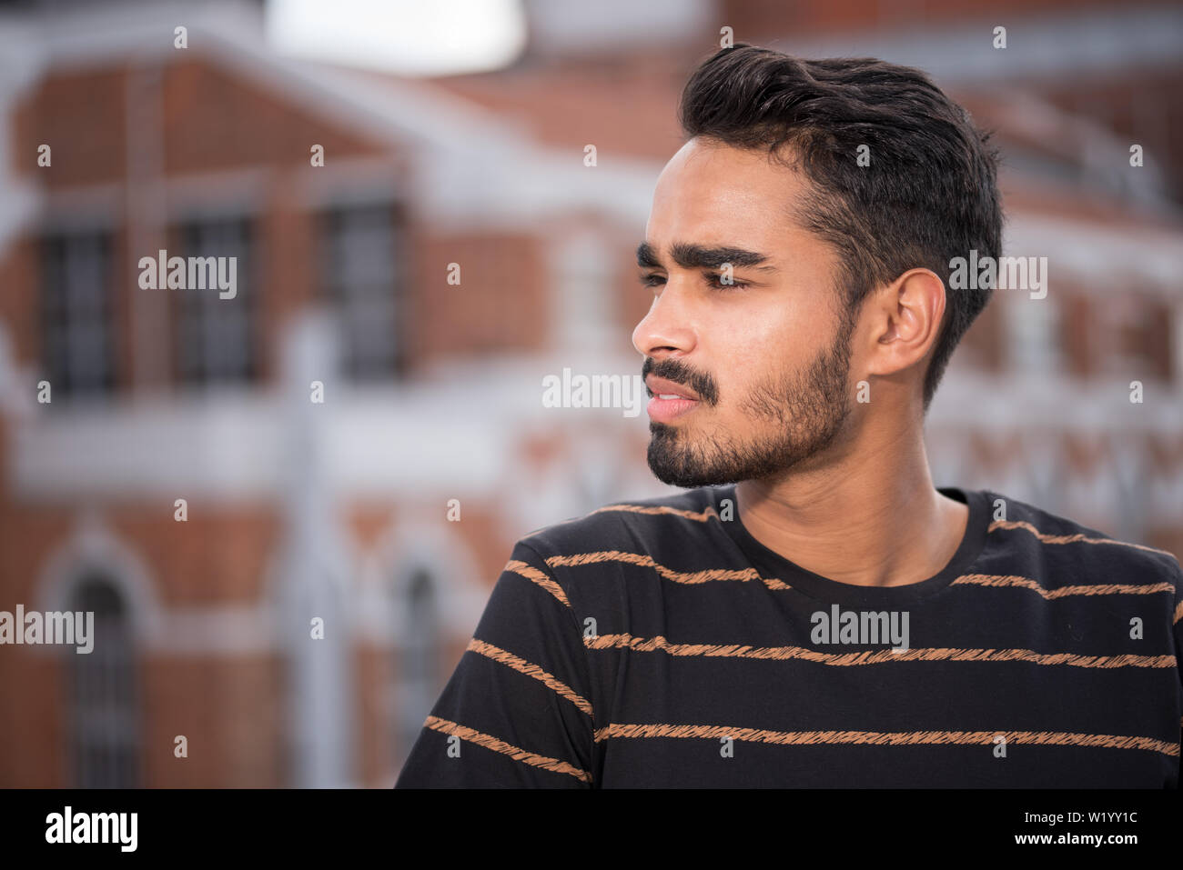 young male model posing in front of old industrial building in Lisbon ...