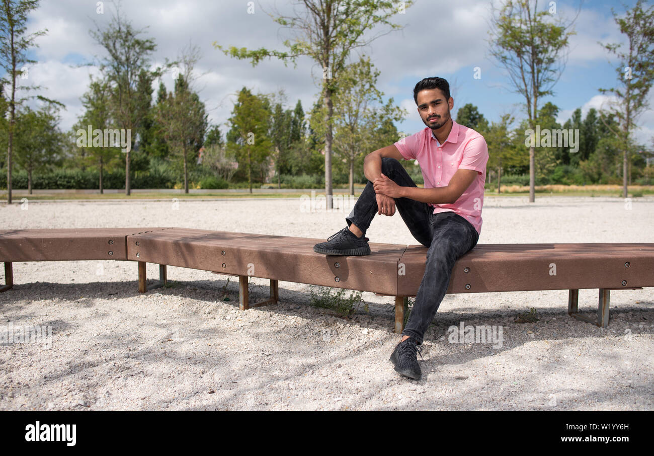 Young man sitting bench garden hi-res stock photography and images - Alamy