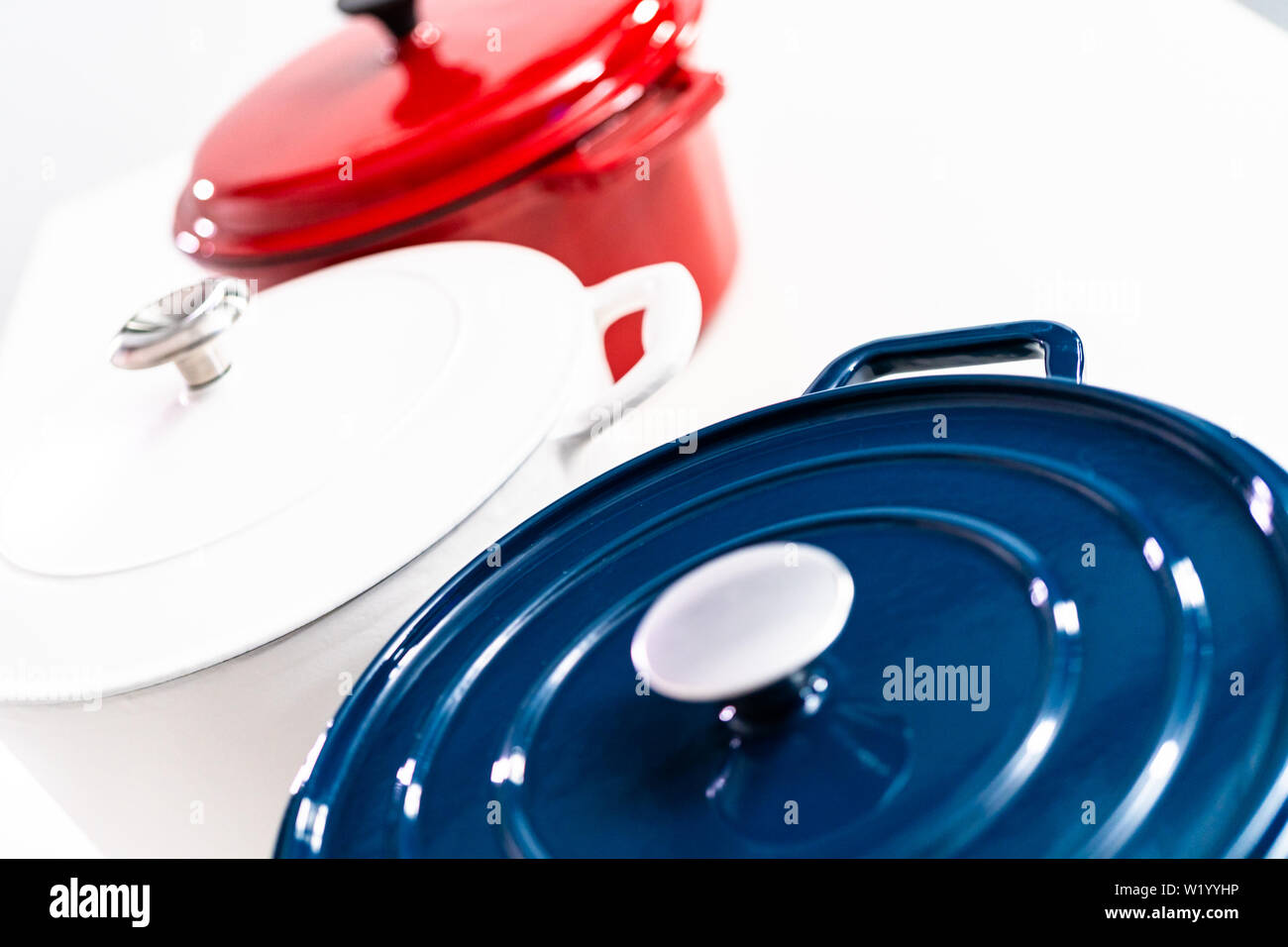 Red, white and blue enameled cast iron covered round dutch ovens on a ...