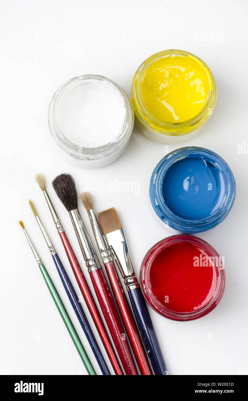 jars of acrylic primary colors plus white with assorted brushes on a ...