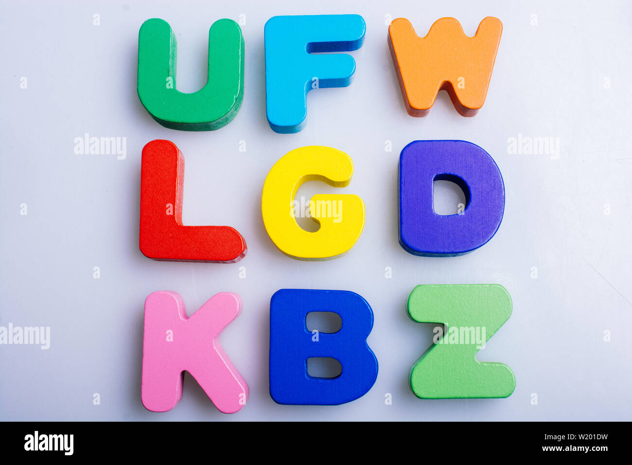Colorful wooden letters scattered on a white background Stock Photo - Alamy