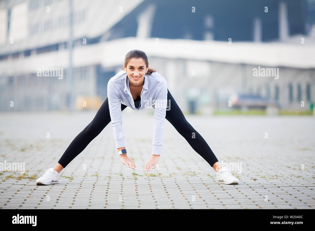 Fitness woman doing workout standing in a stadium background Stock ...