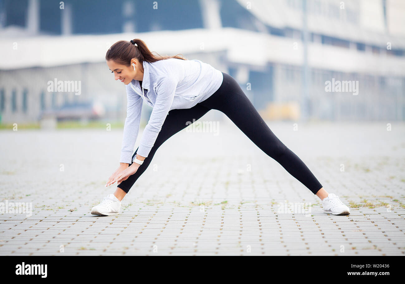 Fitness woman doing workout standing in a stadium background Stock ...